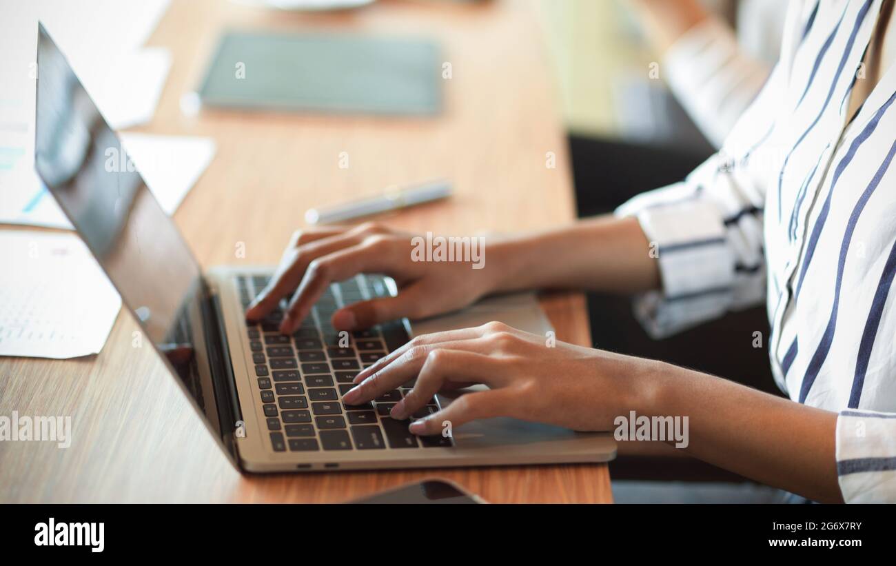 Side view of smart businesswoman typing, working, browsing on laptop ...