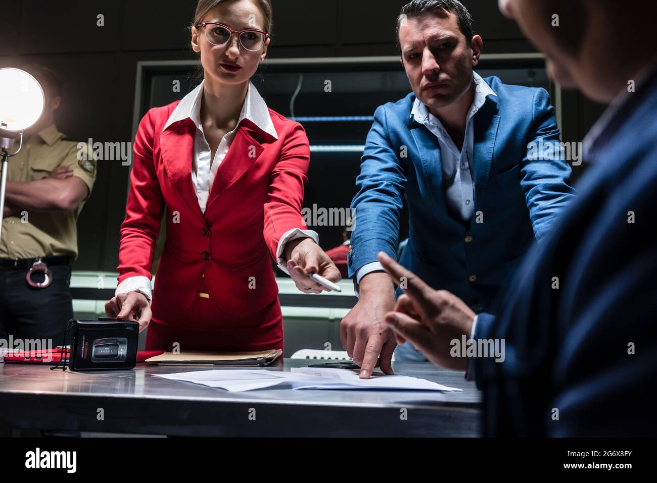 Low angle view of a female police officer aiming with gun against blue ...