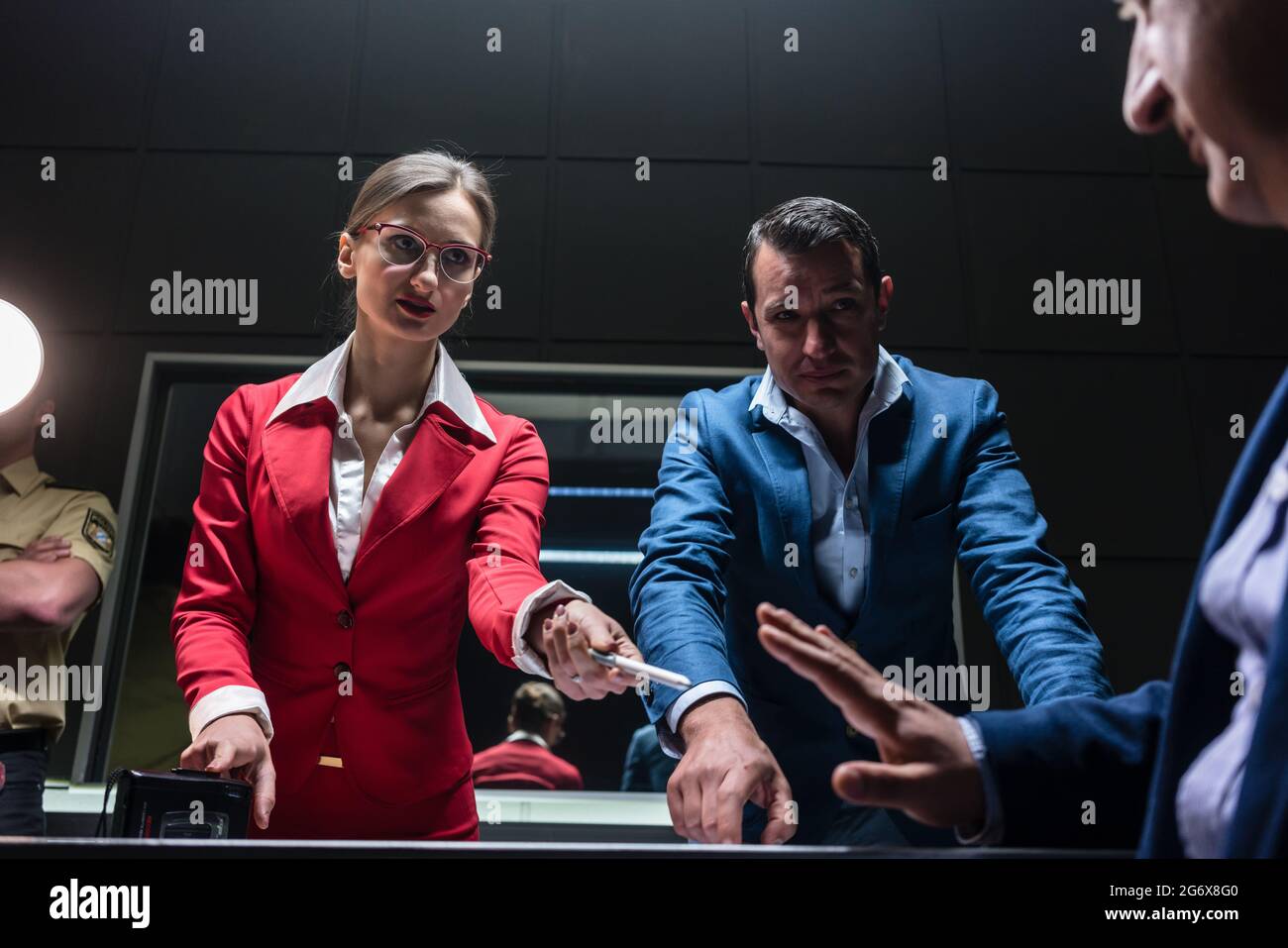 Low-angle view of two persuasive investigators trying to obtain a ...