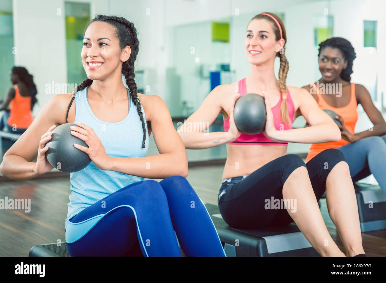 Beautiful young woman exercising Russian twist with med ball from ...