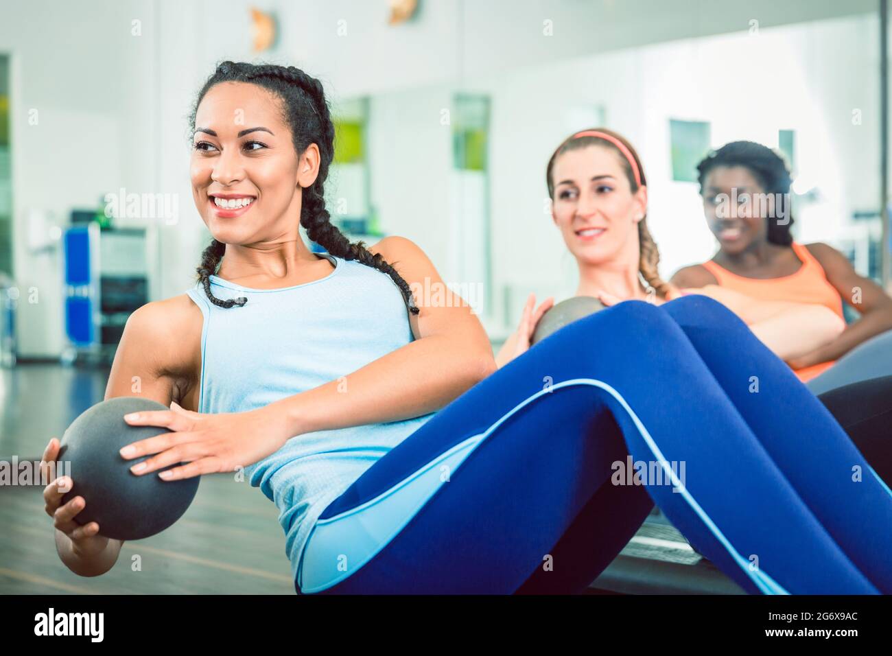 Beautiful young woman exercising Russian twist with med ball from ...