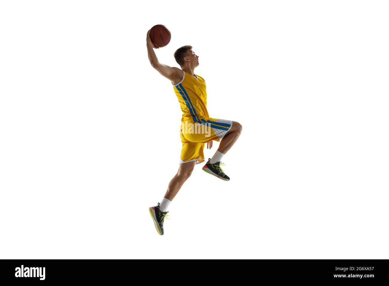 Side view. One young man, basketball player with a ball training ...