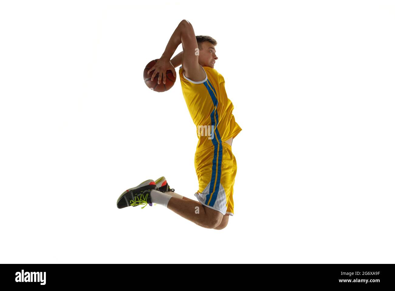 Side view. One young man, basketball player with a ball training ...