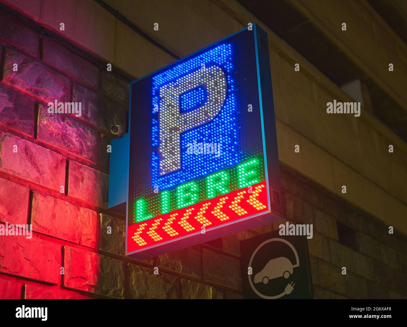 detail of a luminous public parking sign on the wall, indicating free ... detail of a luminous public parking sign on the wall, indicating free ...
