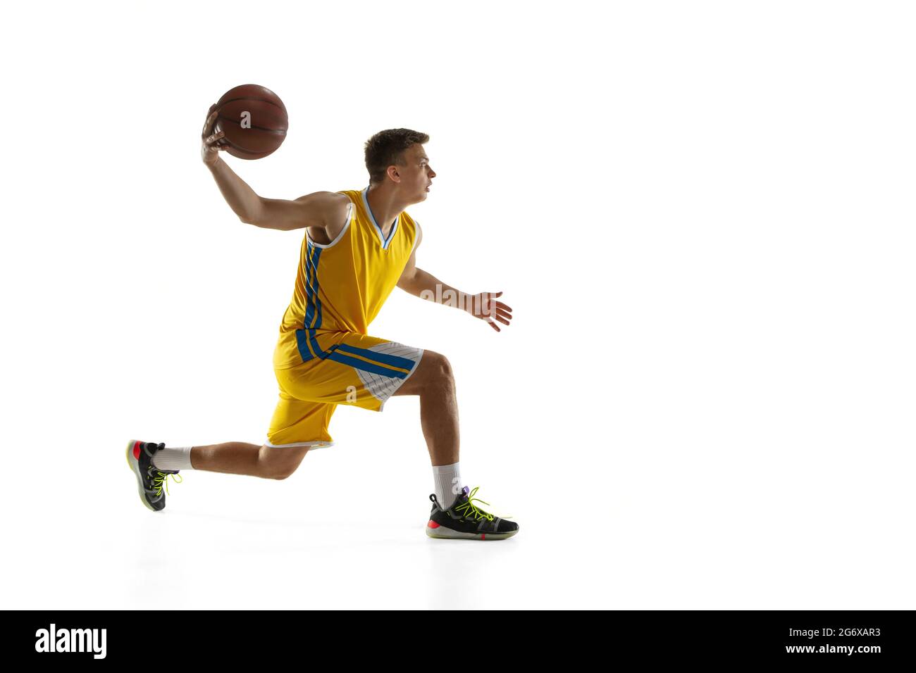 Side view. One young man, basketball player with a ball training ...