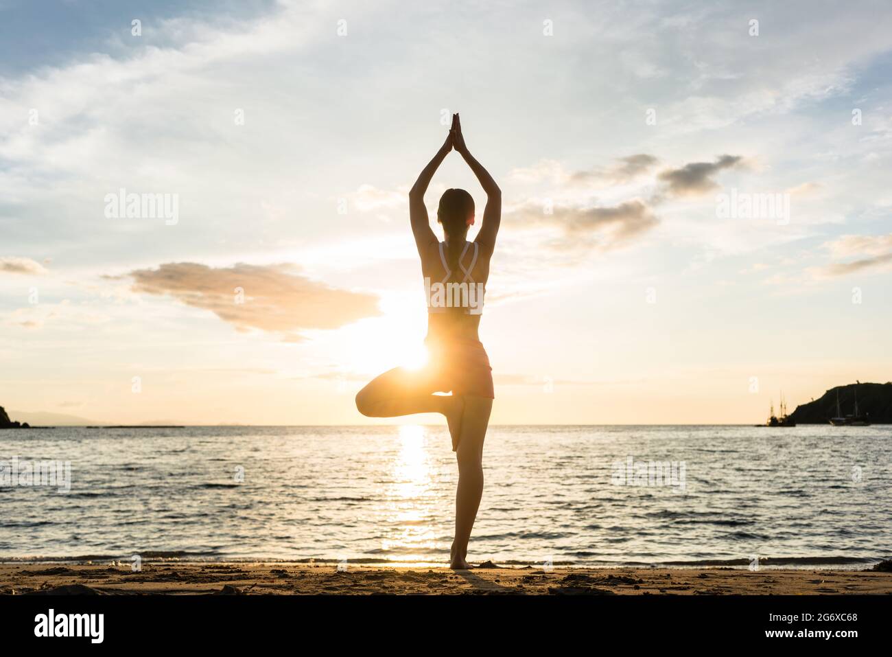 Young woman tree position beach hi-res stock photography and images - Alamy