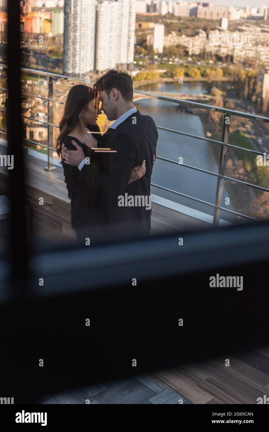 side view of man hugging elegant woman on roof Stock Photo - Alamy