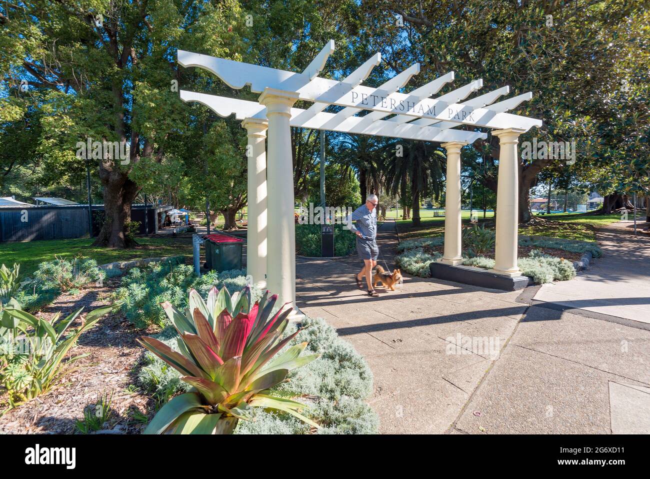A painted timber pergola arch with Tuscan columns at the entrance to ...