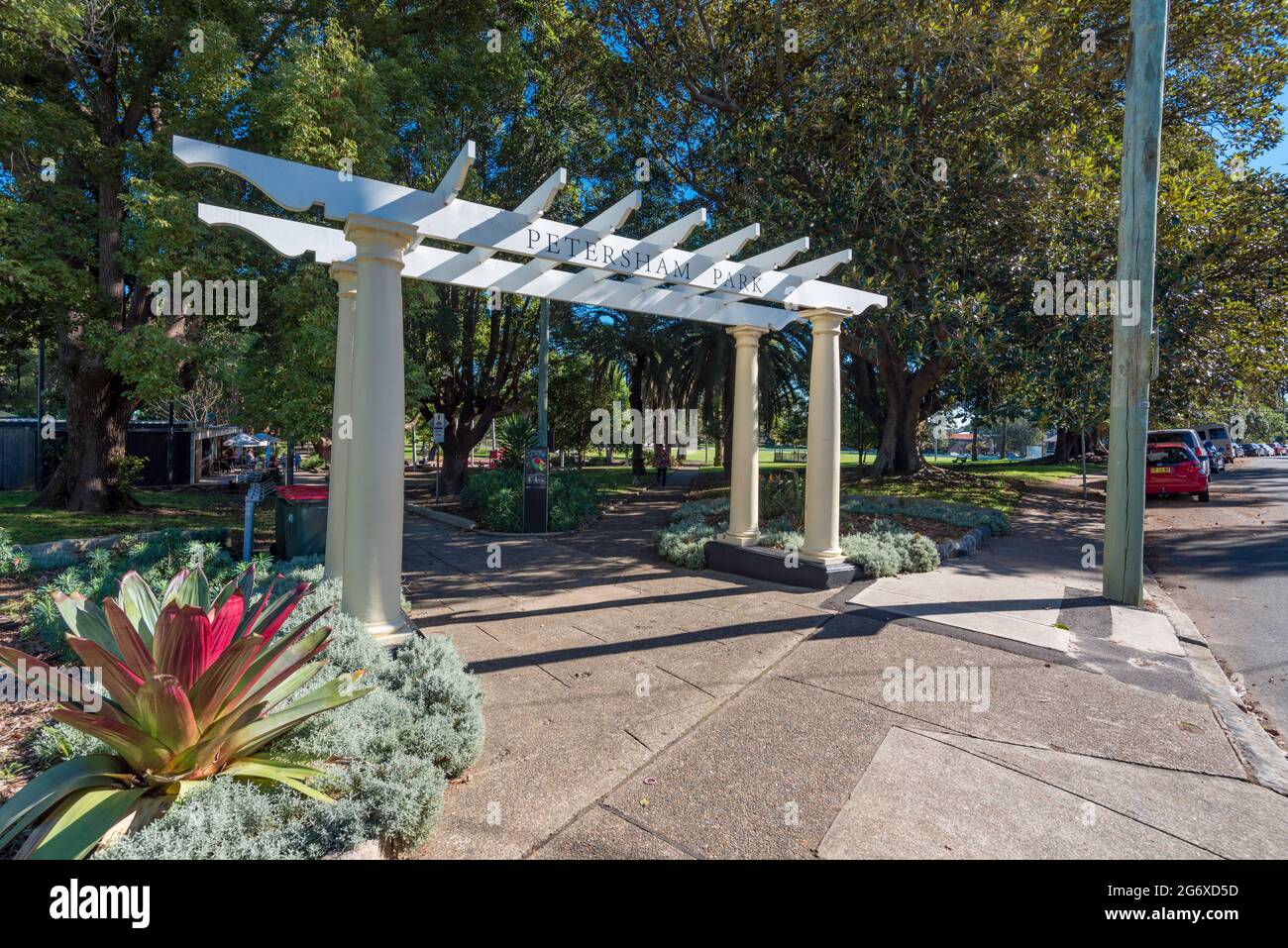 A painted timber pergola arch with Tuscan columns at the entrance to ...