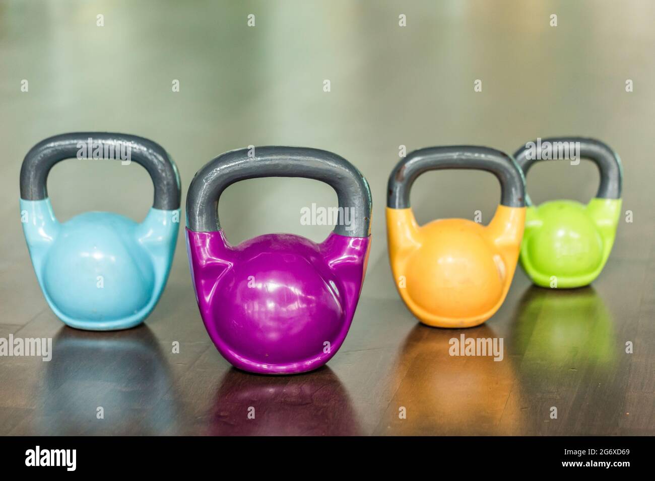 Close-up of four kettlebells of different colors and weights for ...
