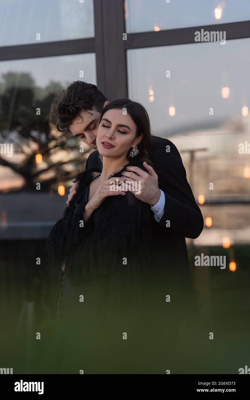man hugging elegant woman in faux fur jacket outdoors Stock Photo - Alamy
