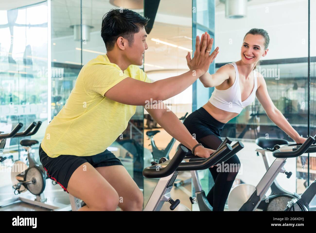 Cheerful young man and his beautiful workout partner and friend giving ...