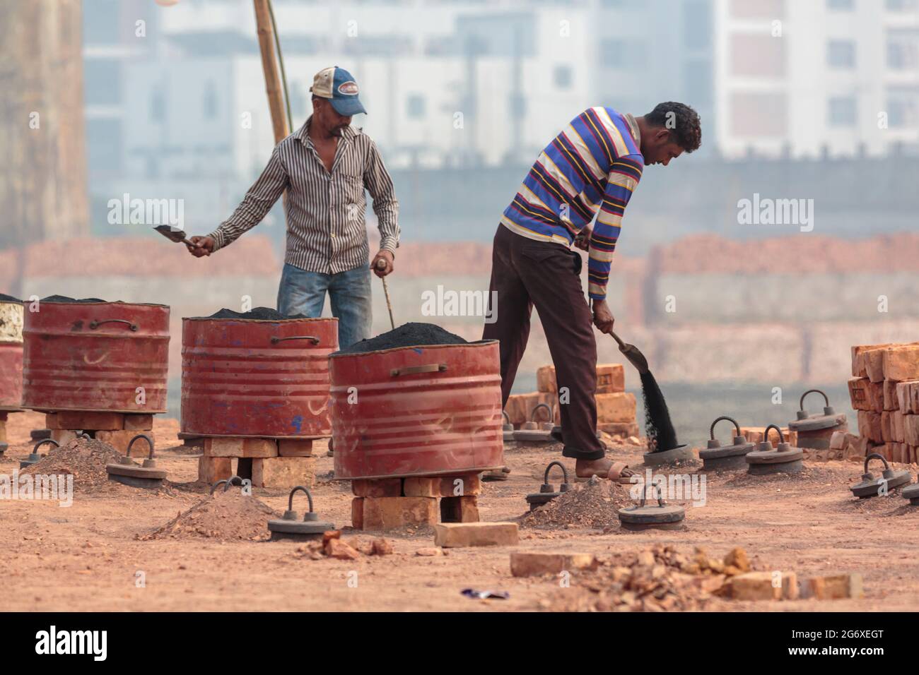 Workers pouring coal dust into brick kiln i Ashulia outside Dhaka ...