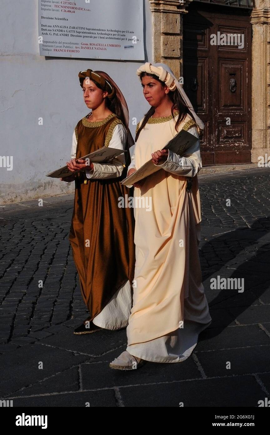 Two young ladies wearing typical Italian medieval costume carry ...