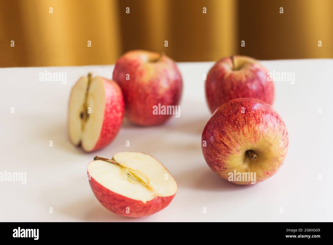 Apples on a white table over a yellow curtain background, horizontal ...