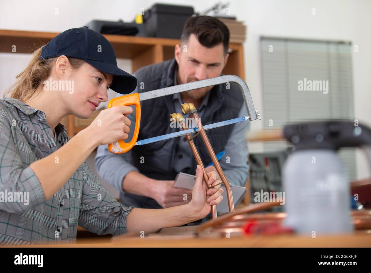 female worker using hacksaw to cut copper pipe Stock Photo Alamy