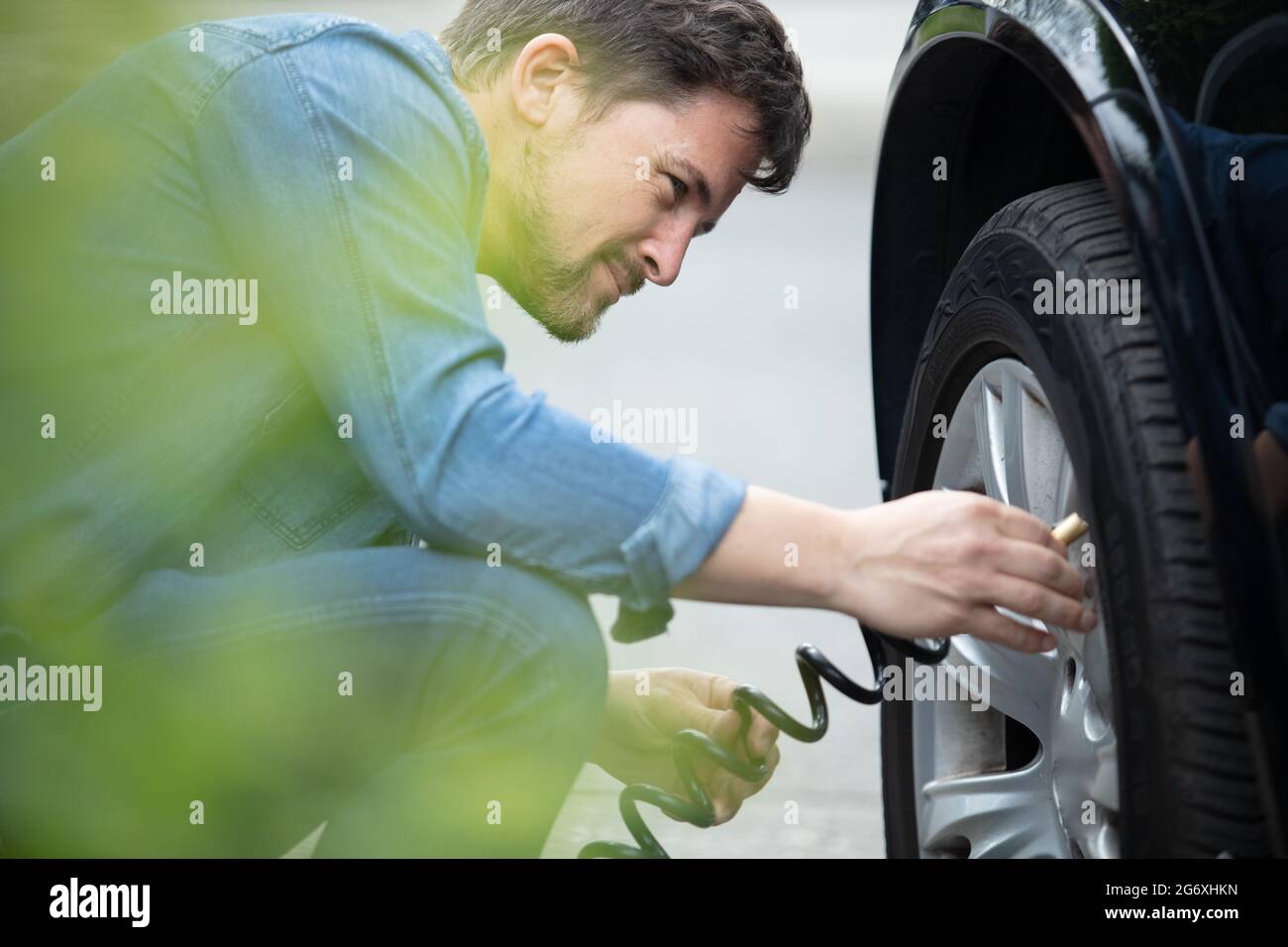 man checking tyre pressure with gauge Stock Photo - Alamy