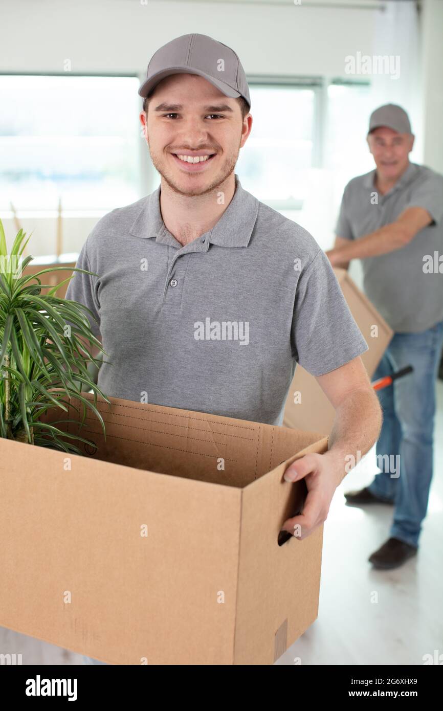 two delivery men carrying cardboard boxes Stock Photo - Alamy