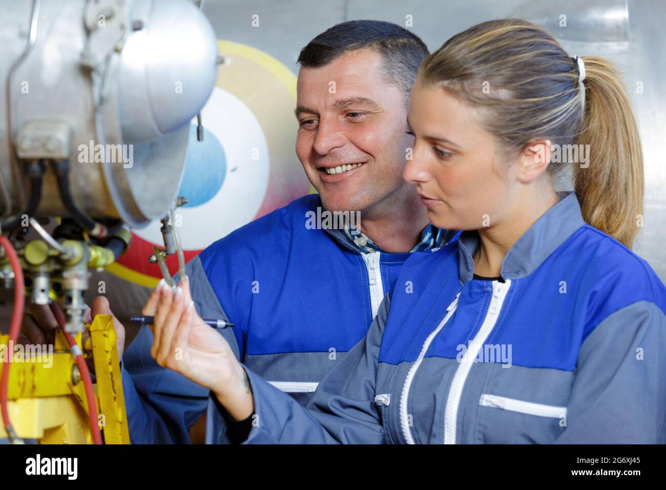 male technician asking his female colleague for help Stock Photo - Alamy