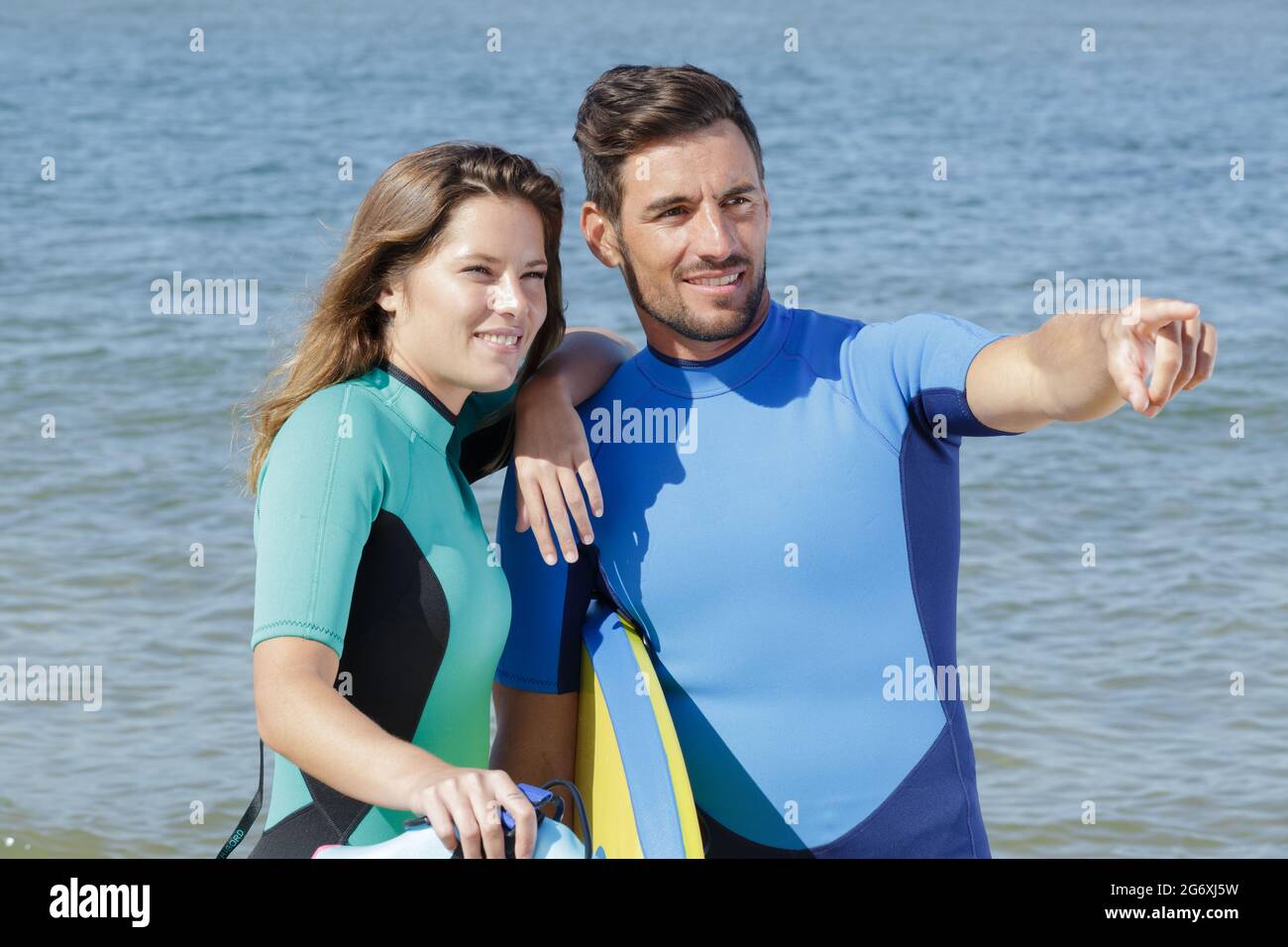 young couple of bodyboard surfers pointing at a wave Stock Photo - Alamy