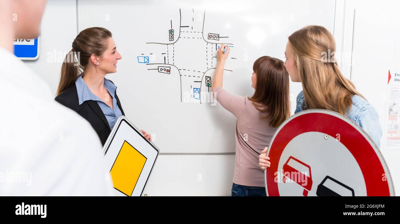 Learner in driving lessons theory explaining traffic situation on white ...