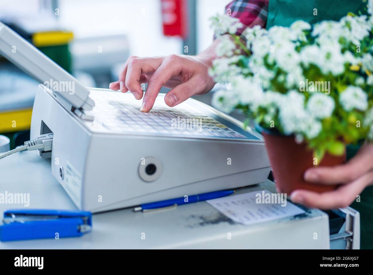 Side view close-up of the hands of a cashier entering into the cash ...