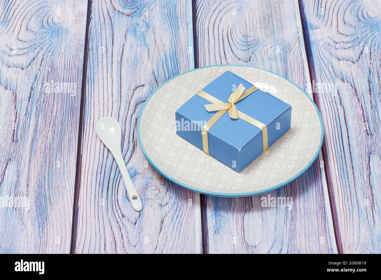 Porcelain plate and gift box on wooden background Stock Photo - Alamy