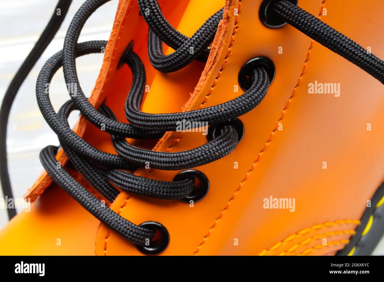 Closeup of one single bright orange color leather boot with black sole ...