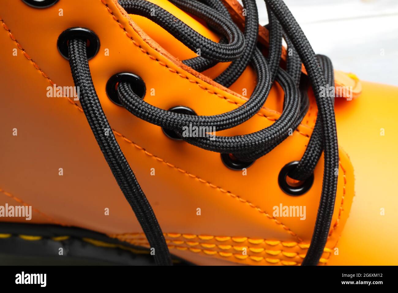 Closeup of one single bright orange color leather boot with black sole ...