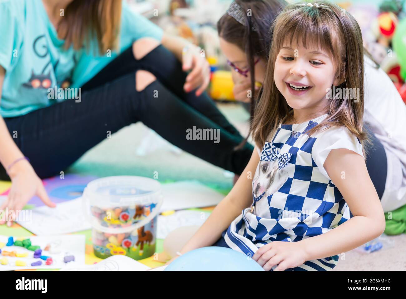 Cheerful pre-school girl wearing a trendy T-shirt while playing on the ...