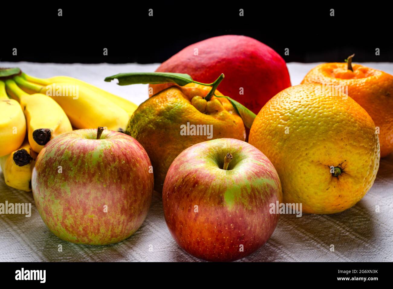 Tropical fruit mix on a table with white tablecloth Stock Photo - Alamy