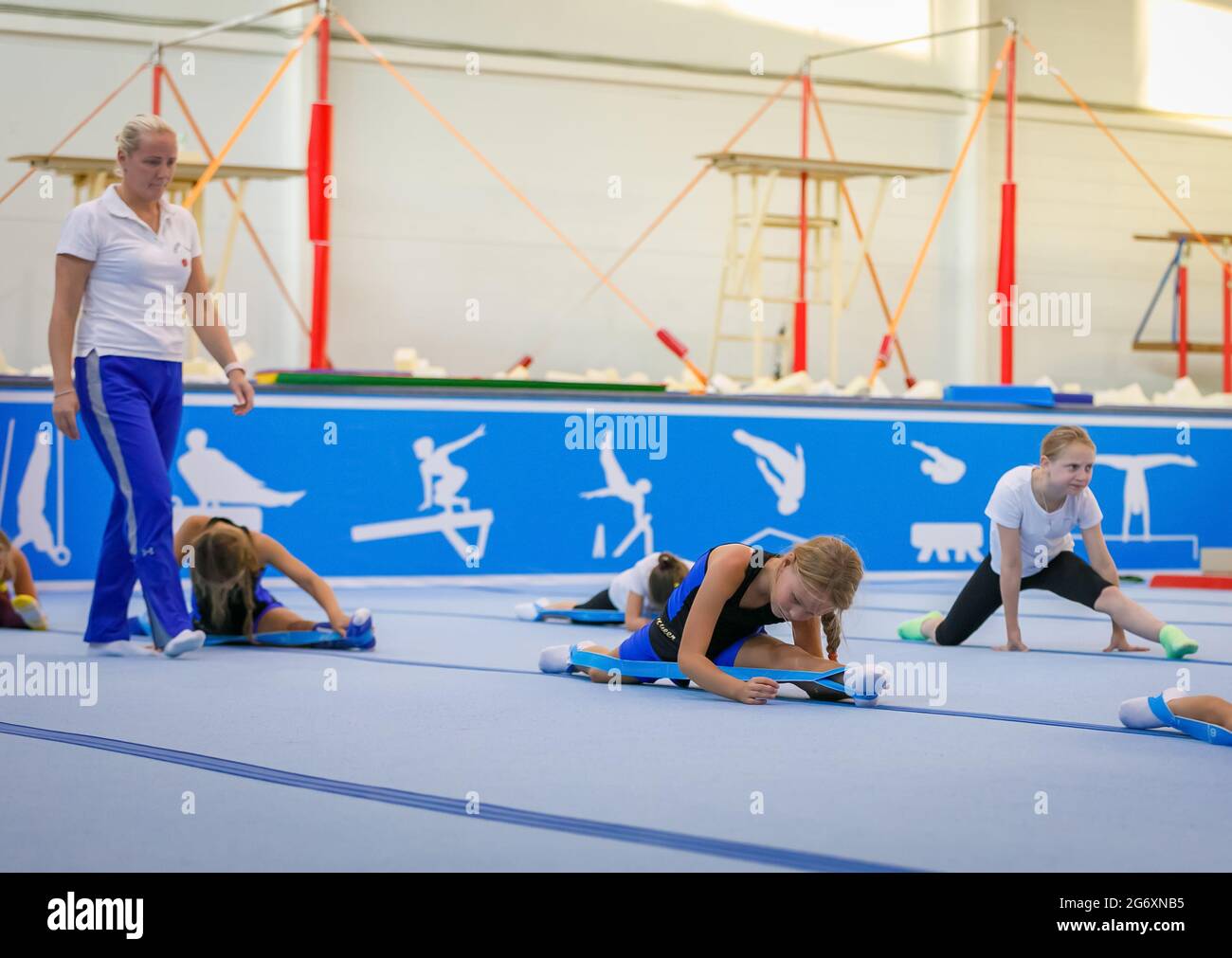 Young athletes perform stretching exercises under the guidance of a ...
