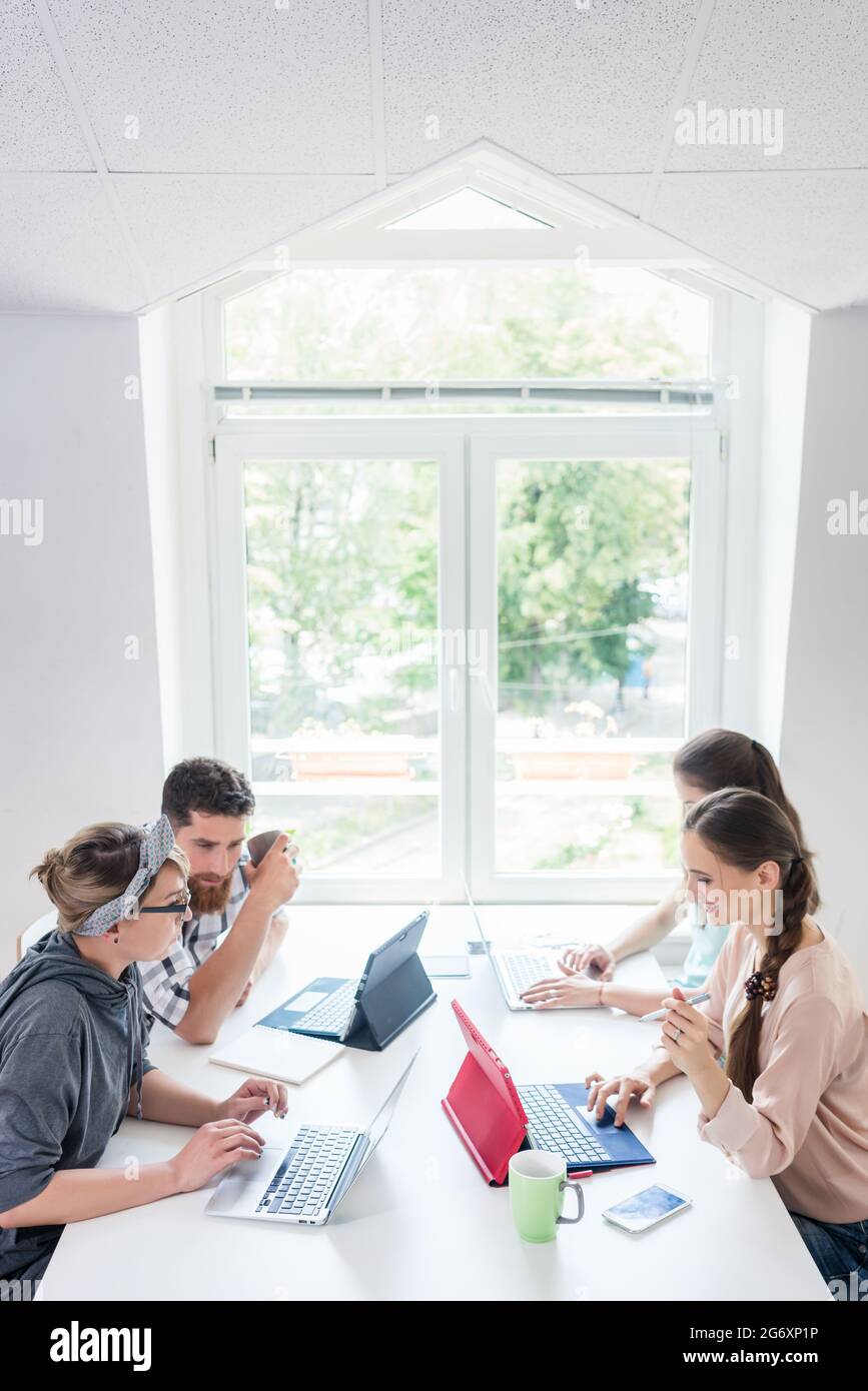 Dedicated young woman editing a document on laptop, while sharing the ...