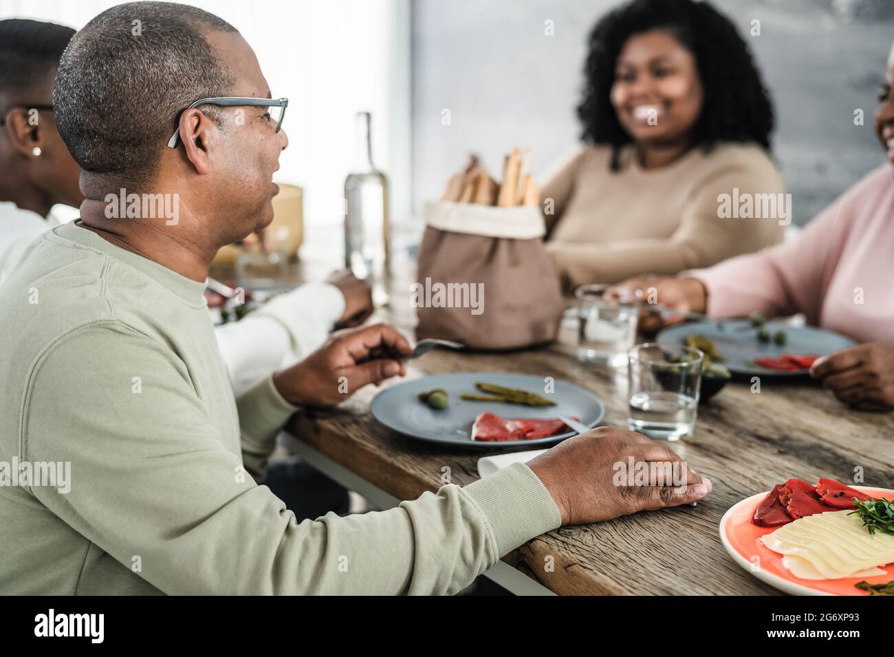 Happy afro Latin family eating healthy lunch with fresh vegetables at ...