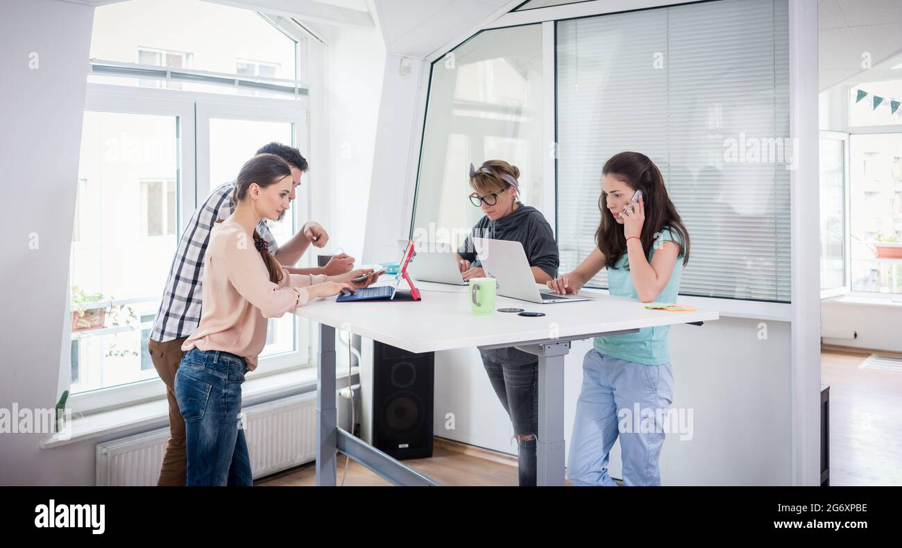 Busy co-workers using mobile technology connected to WI-FI network ...
