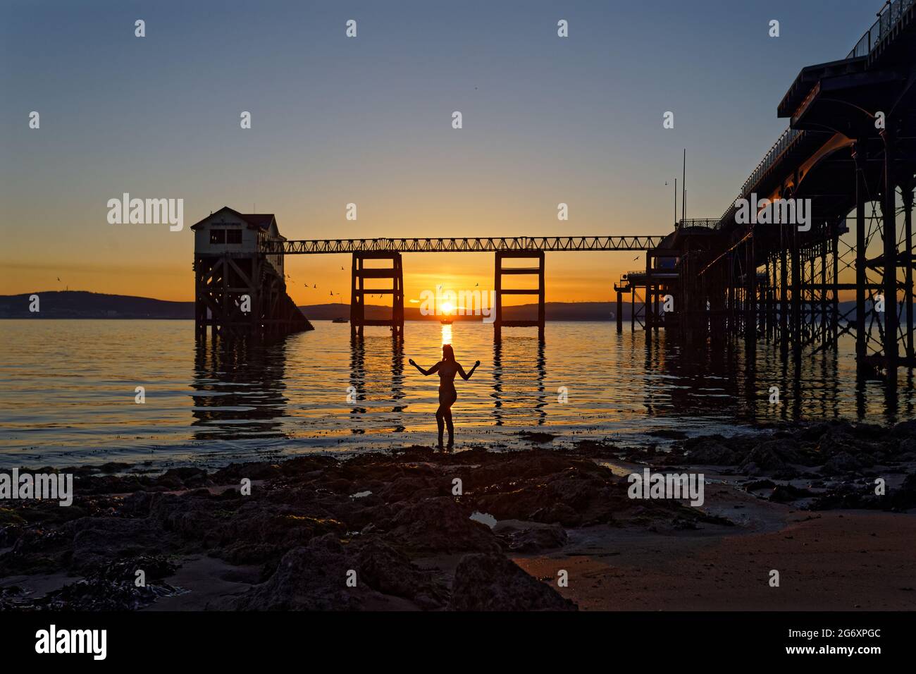 Pictured: Natasha Jenkins in the sea during sunrise as seen through the ...