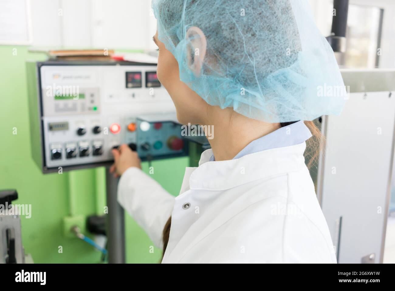 Experienced female manufacturing operator wearing protective headwear ...