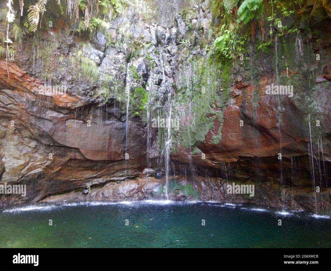 Water falling from the cliff over the pond Stock Photo - Alamy