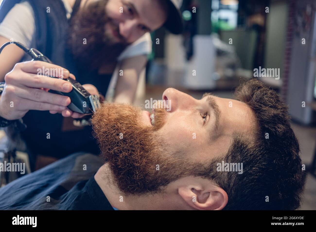 Side view close-up of the head of a redhead young man and the hand of a ...