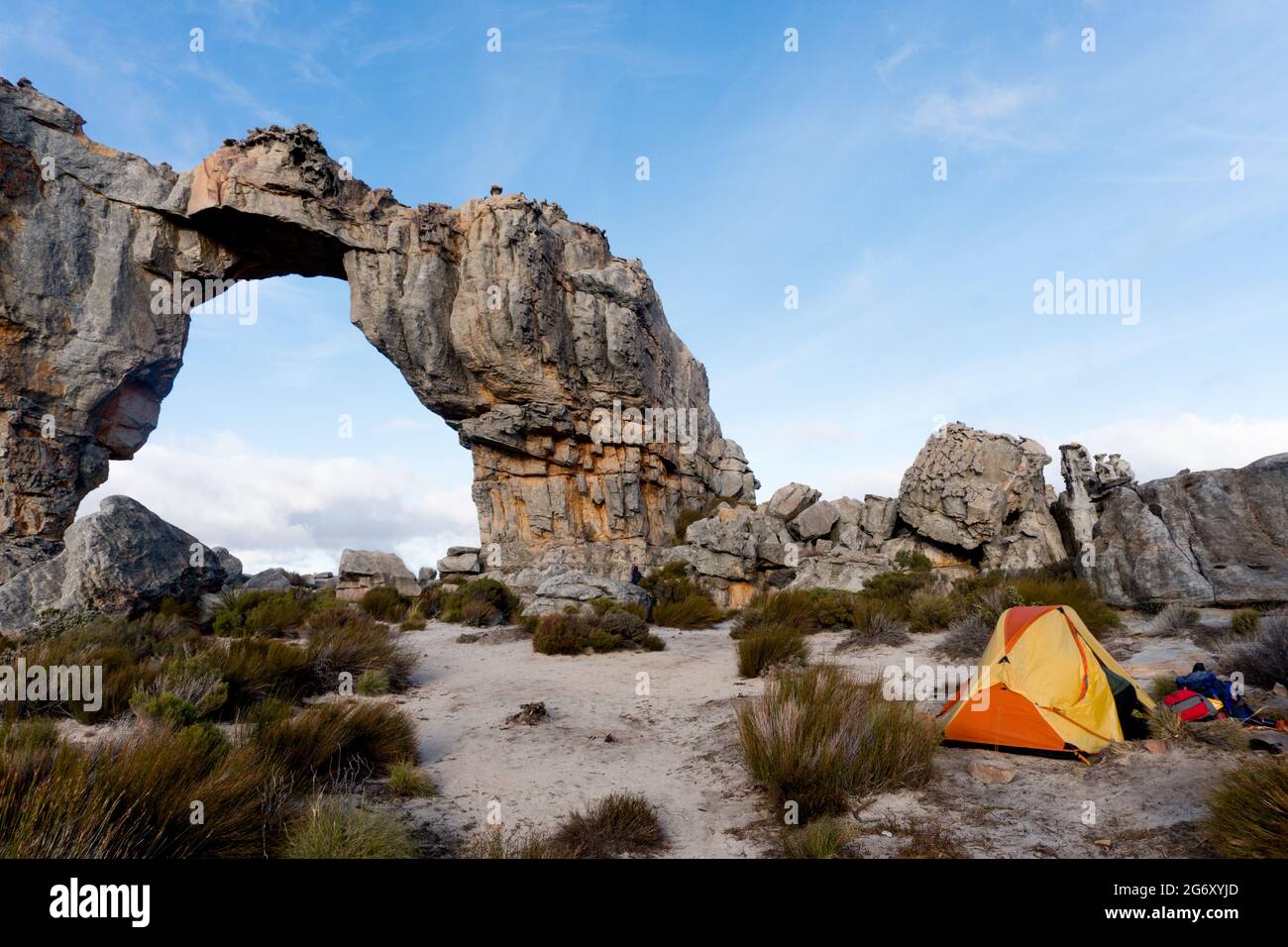 A tent is pitched close to an Arch formed by unique rock formations ...