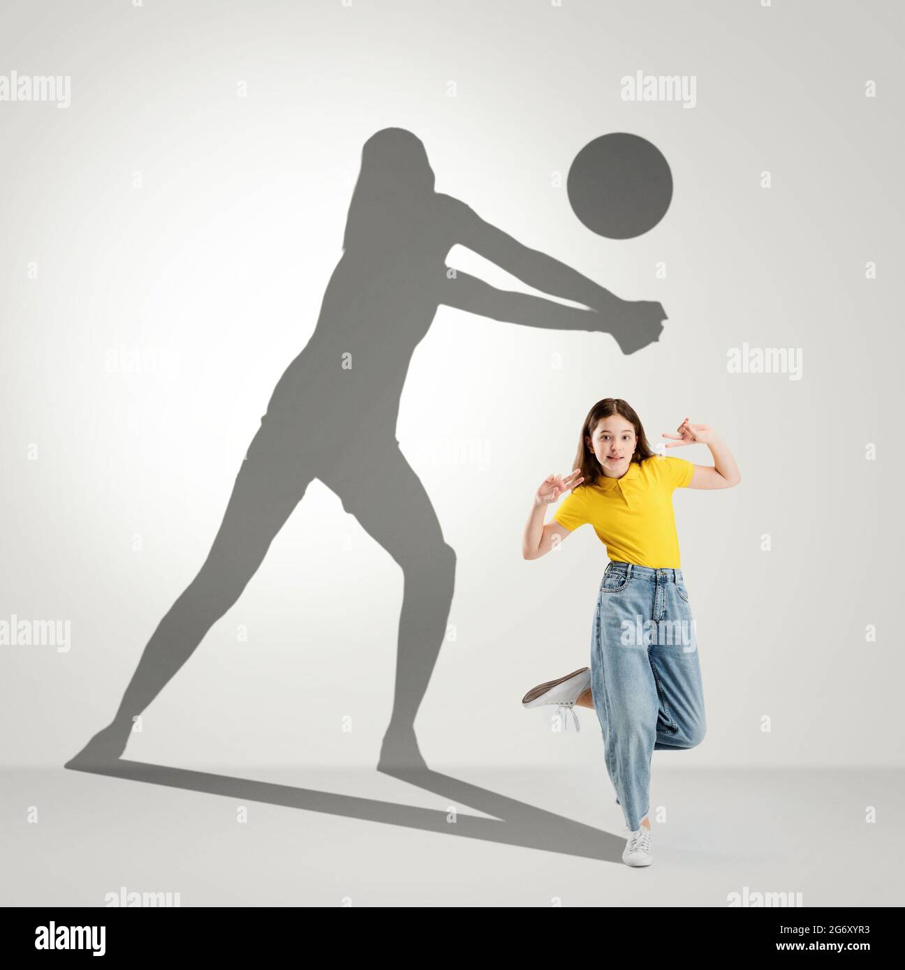 Conceptual image with preschool girl and shadow of female volleyball ...