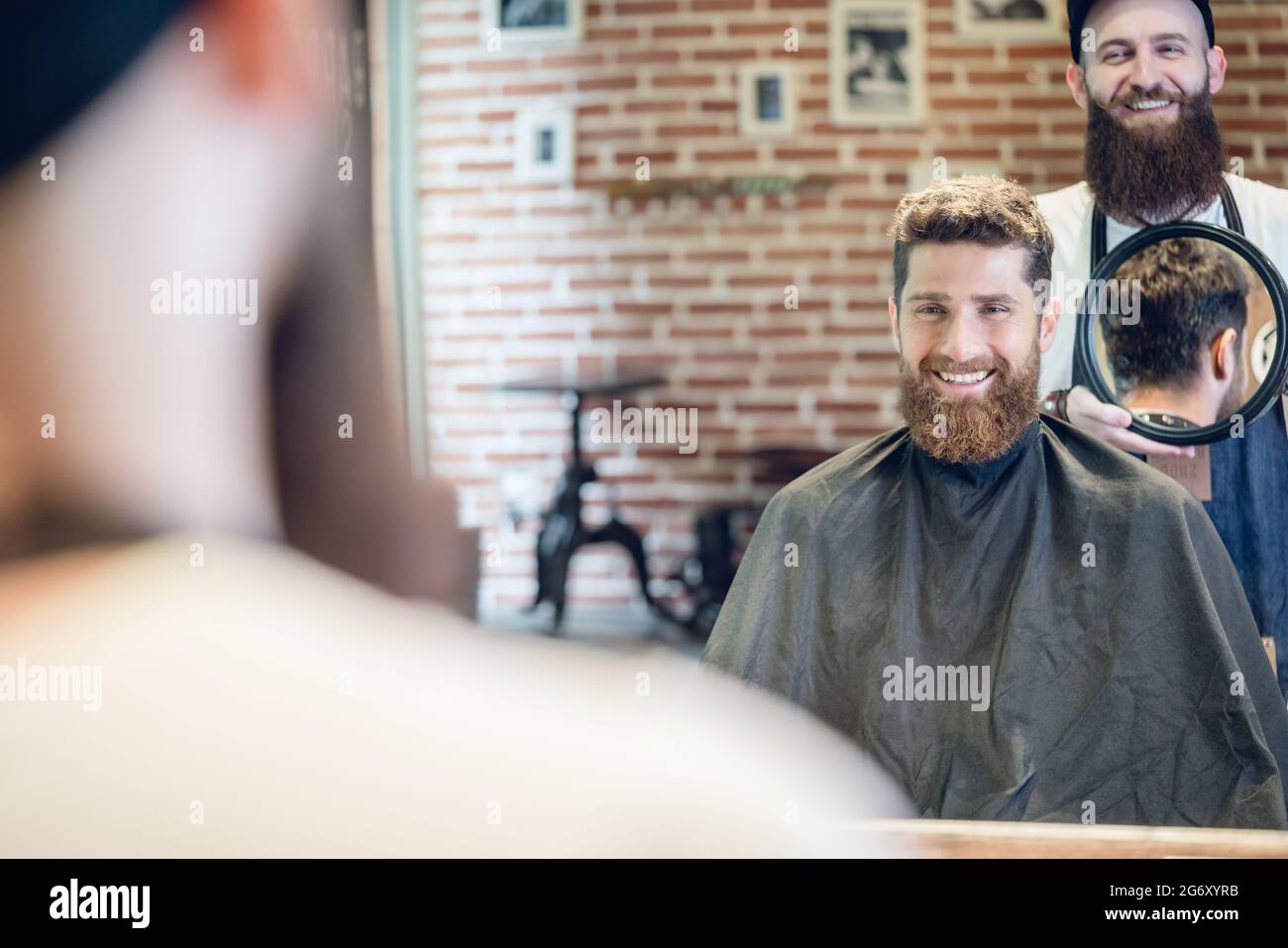 Over the shoulder view of a handsome young man smiling, while looking ...