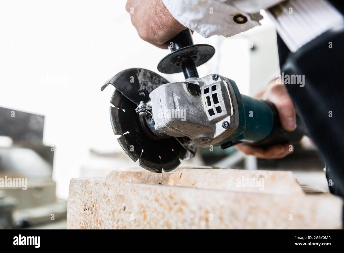 Handyman working at marble stone with disc grinder Stock Photo - Alamy