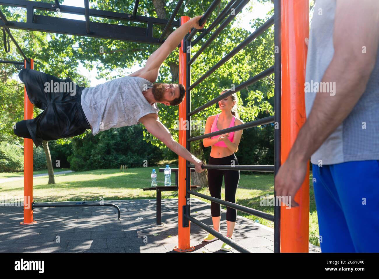Strong and happy young man gripping a vertical bar while practicing ...