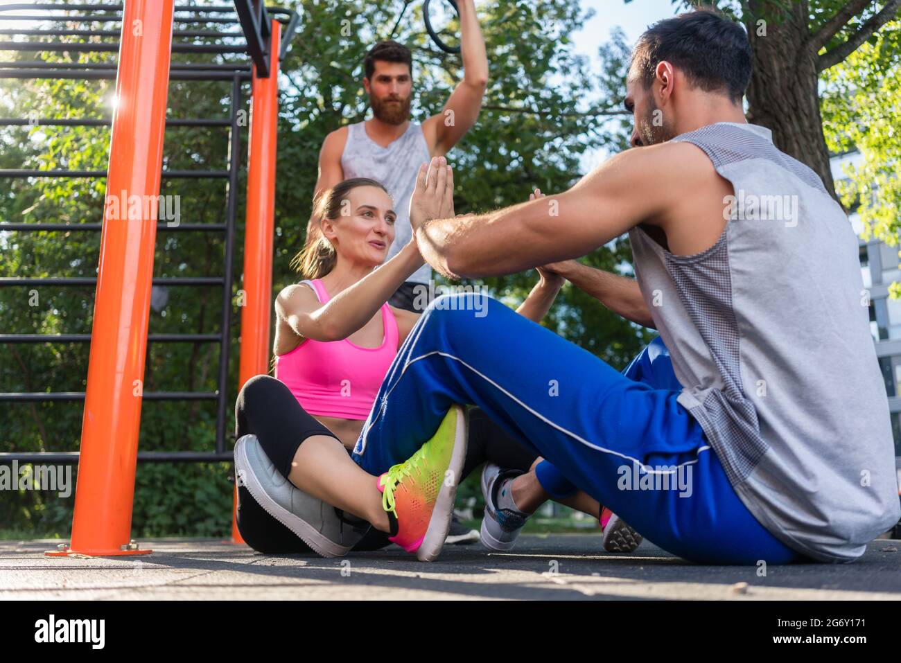 Low-angle view of an athletic couple clapping hands while doing ...