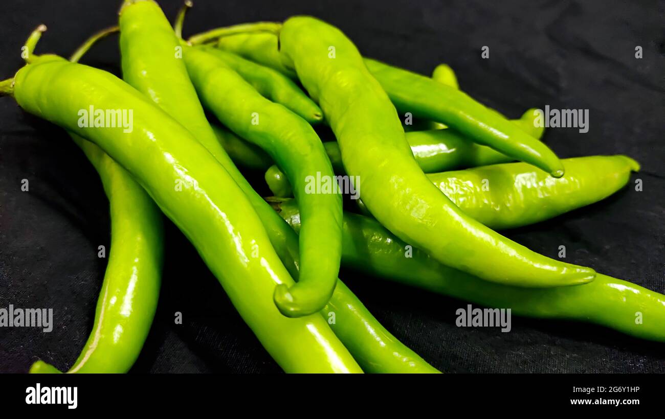 Fresh green chili on black background in india Stock Photo - Alamy