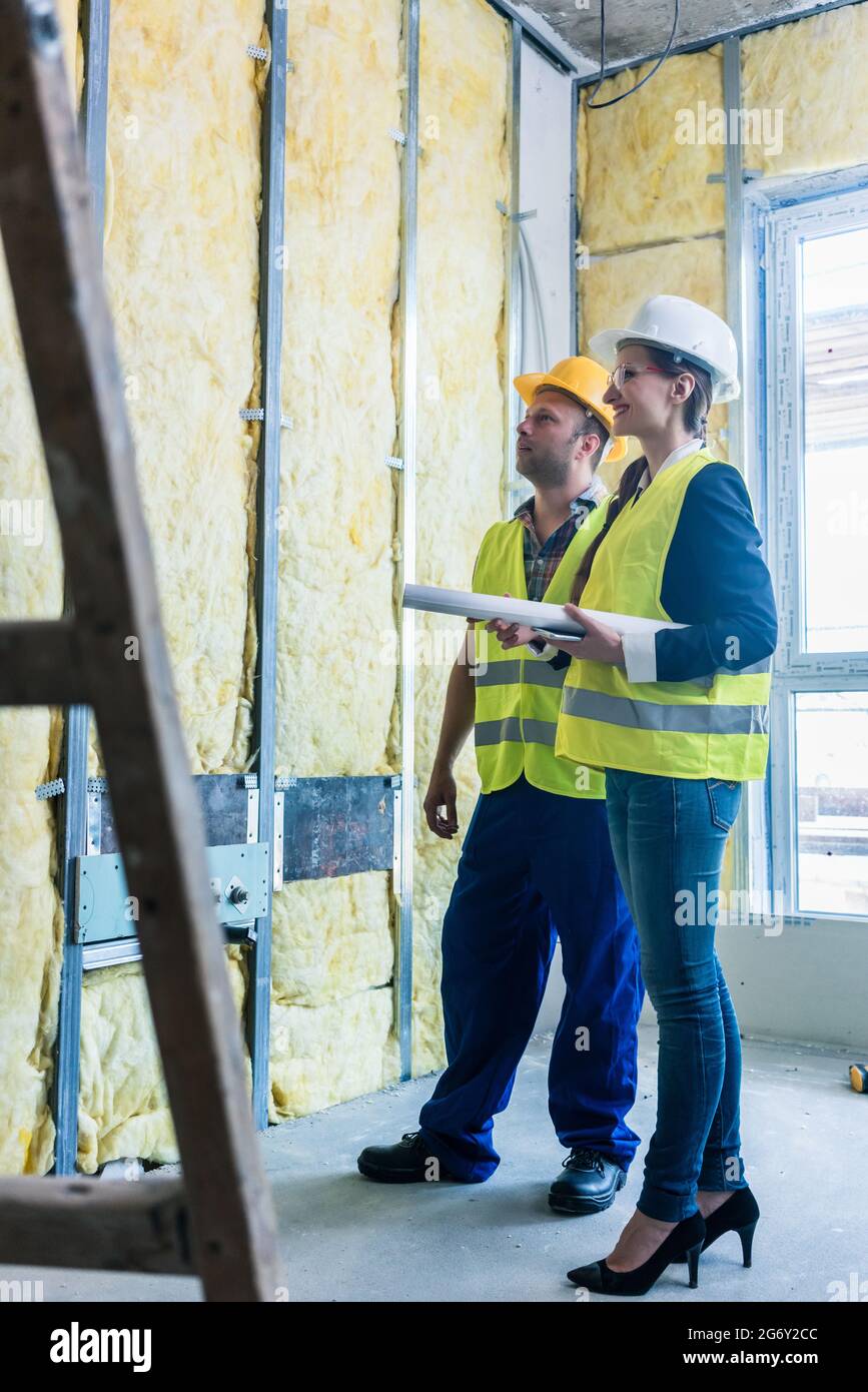 Construction manager and architect checking the insulation works in a ...