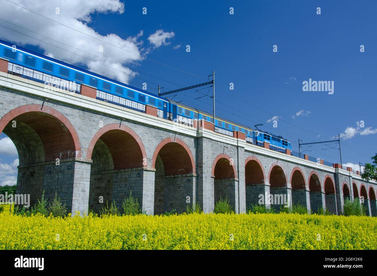 Beautiful scene of viaduct type of bridge with blue train surrounded by ...