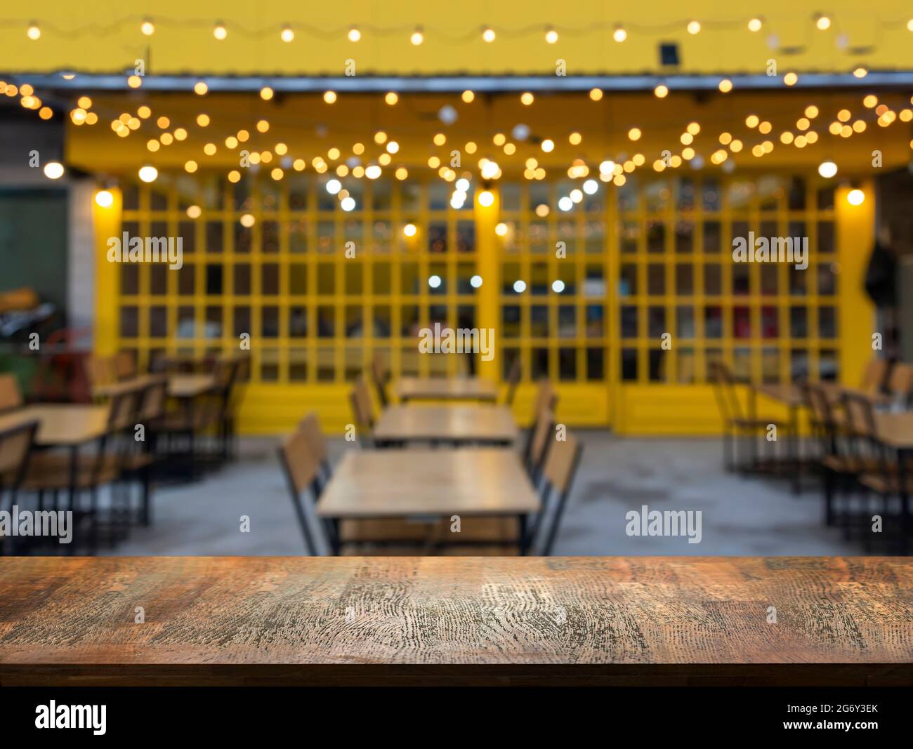 wood table top on yellow restaurant for dinner party display food and ...