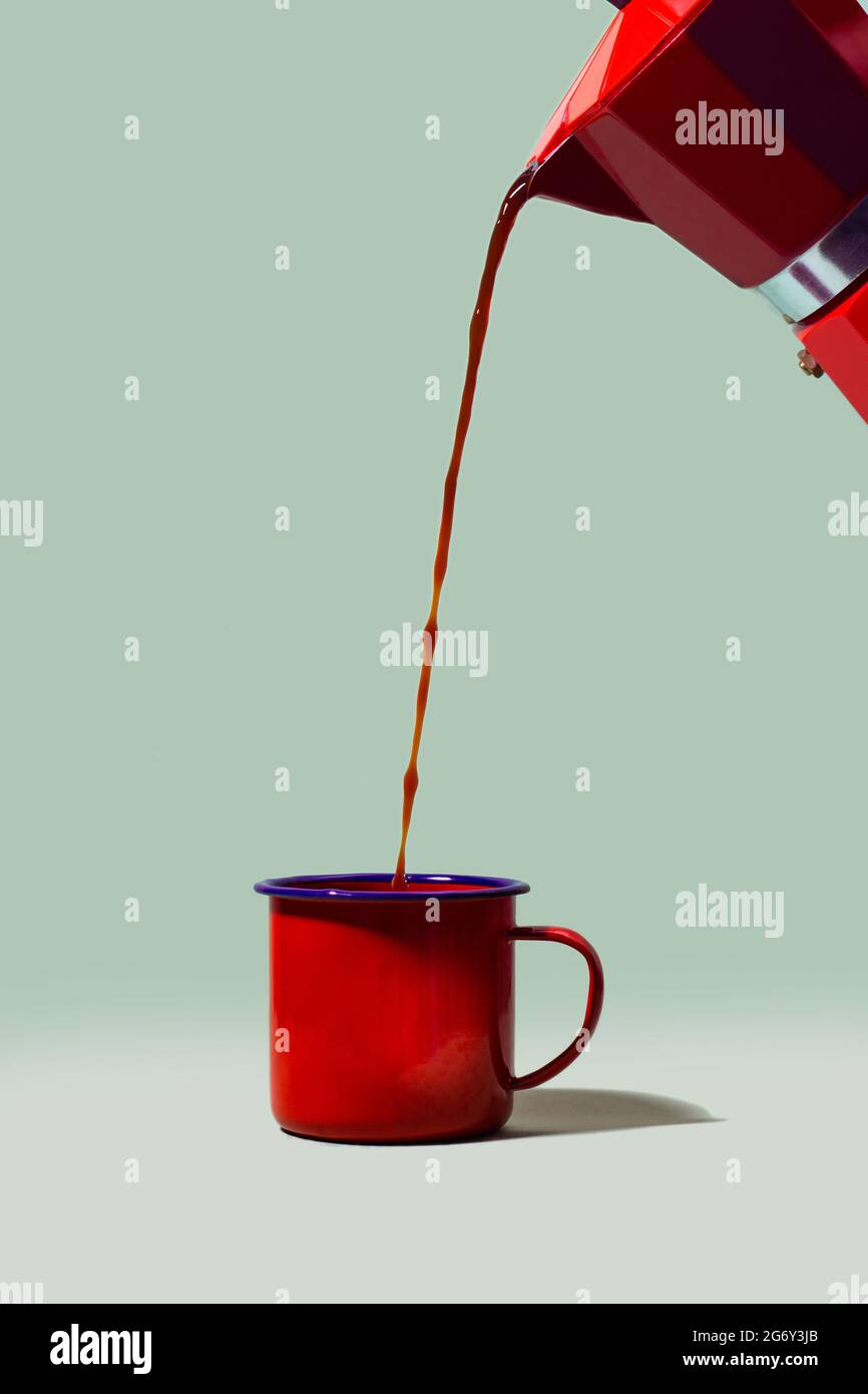 Pouring coffee in the red mug with green background Stock Photo - Alamy